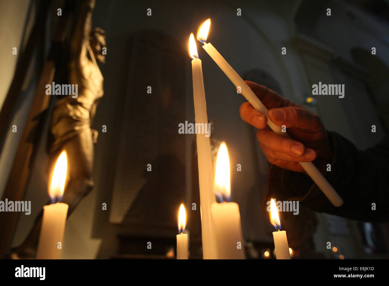 Pilgrim lighting a candle Stock Photo - Alamy