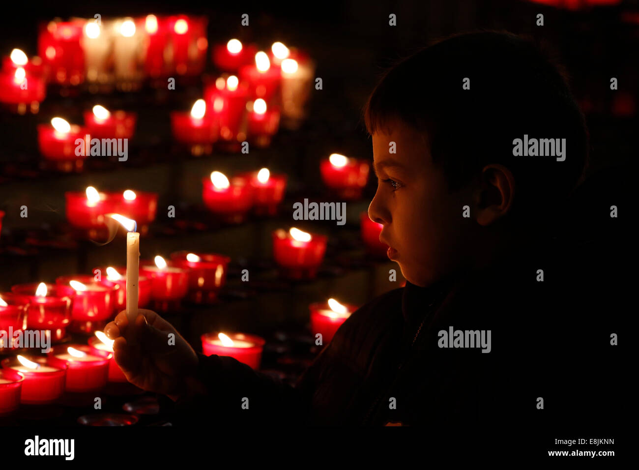 Child lighting a church candle Stock Photo - Alamy