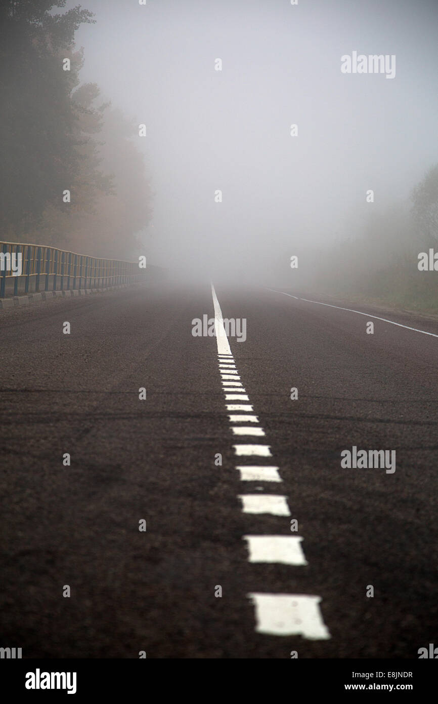 Asphalt road in an autumn fog Stock Photo - Alamy