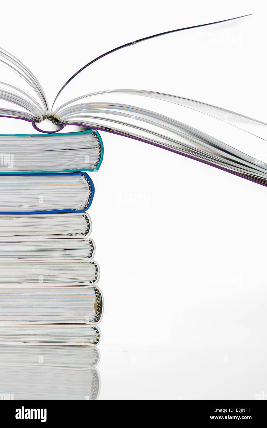 side-on view of a stack of books, portrait photograph, white background ...