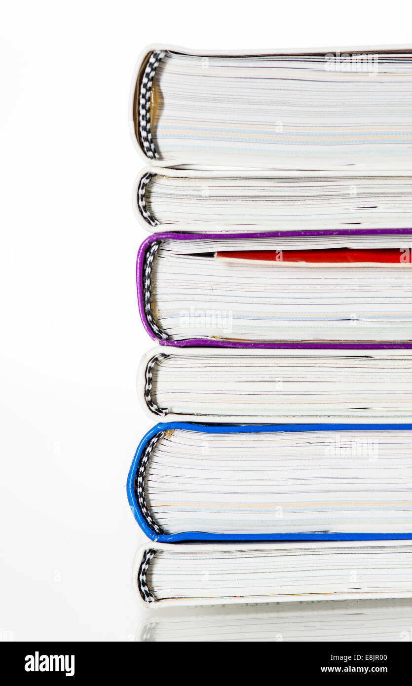 side-on view of a stack of books, portrait photograph, white background ...