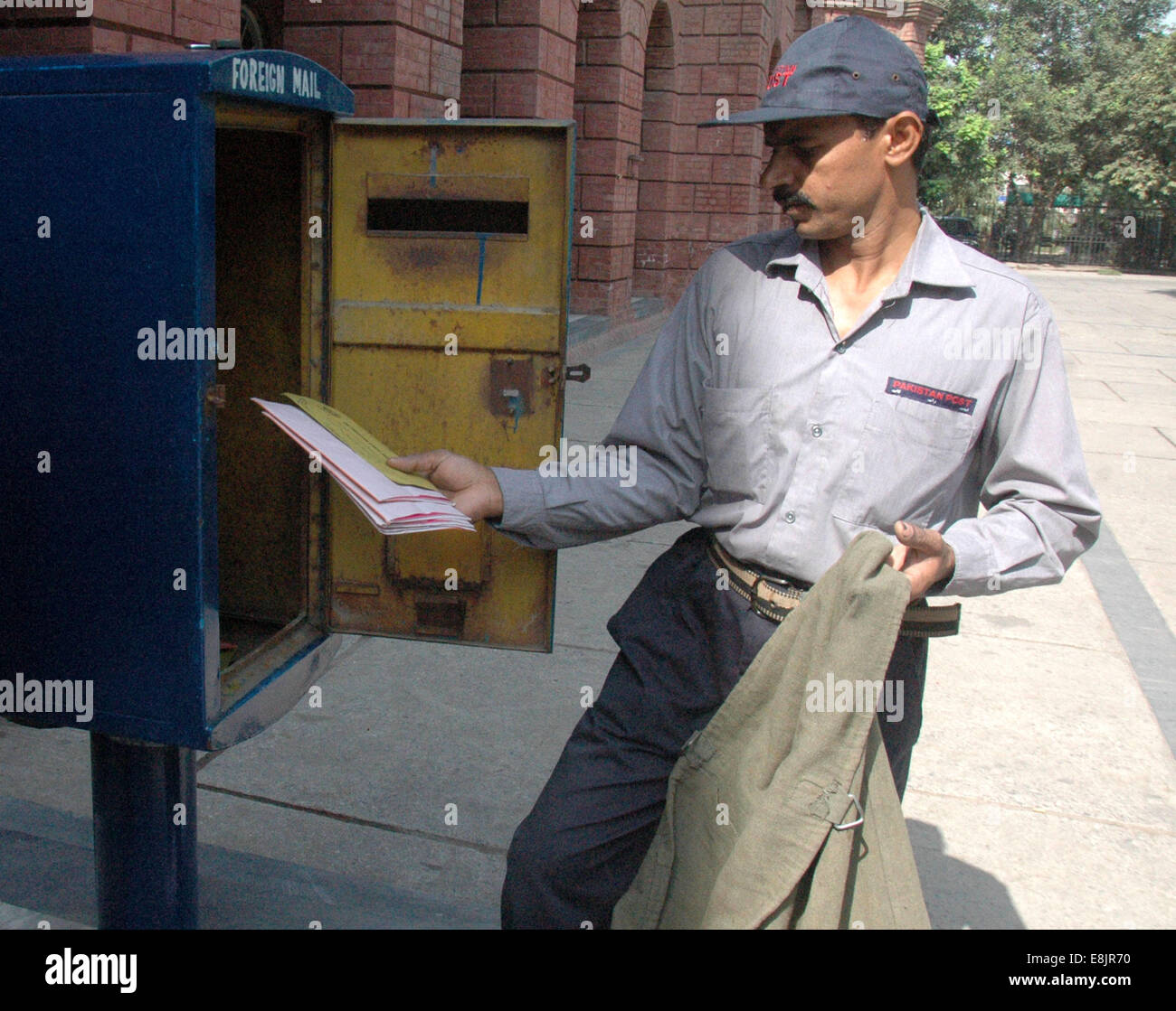 Lahore. 9th Oct, 2014. A Pakistani postman collects letters from a ...