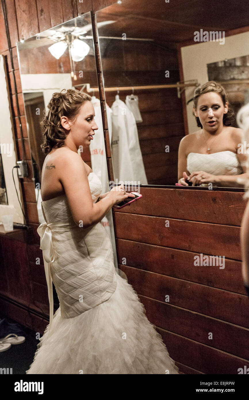 Bride dressing up for her wedding dress with help of brides maids Stock ...