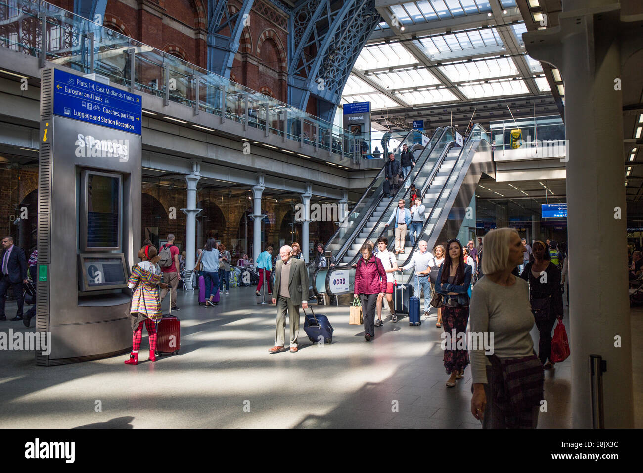 passengers on the lower concourse and an escalator between the two ...