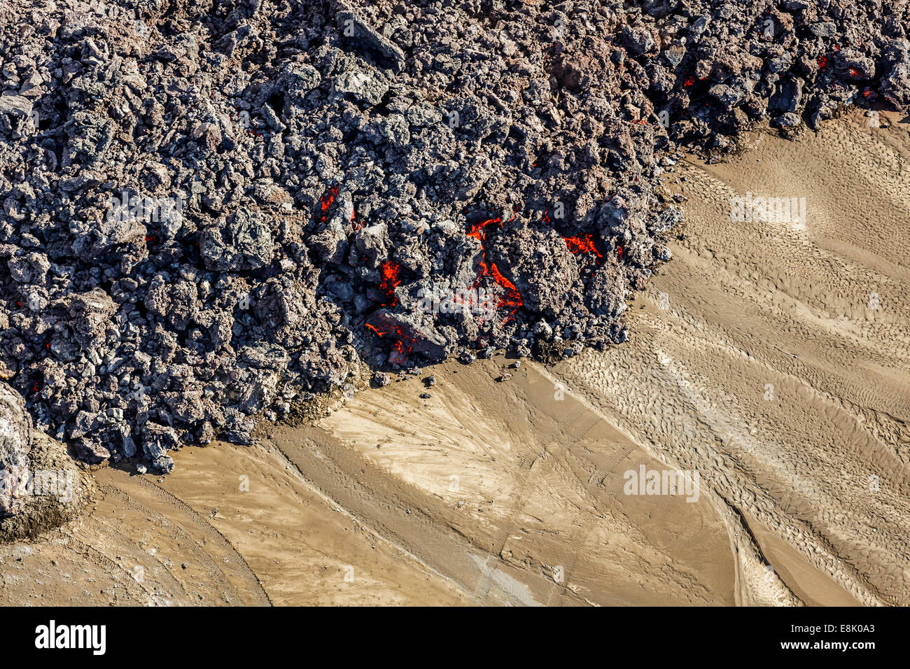 Hot lava creeping by tire tracks. Eruption site at Holuhraun near ...
