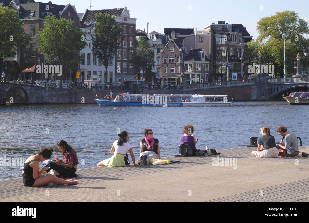 People relaxing by River Amstel Amsterdam Holland Stock Photo - Alamy