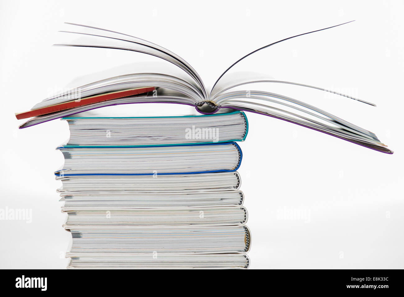 side-on view of a stack of books, portrait photograph, white background ...