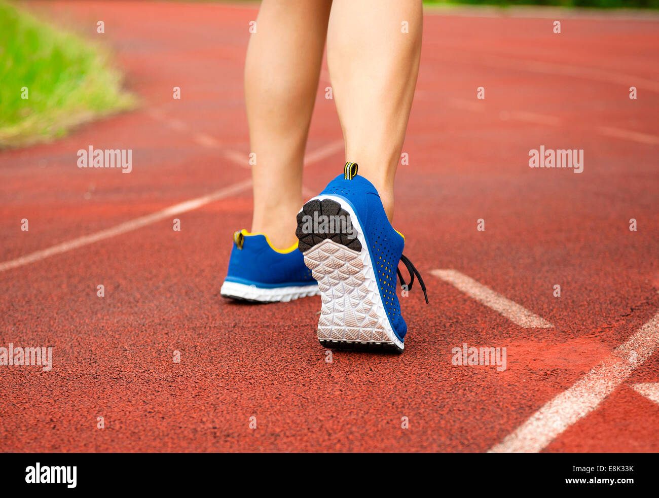 runner feet running on track and closeup of shoe. workout wellness ...