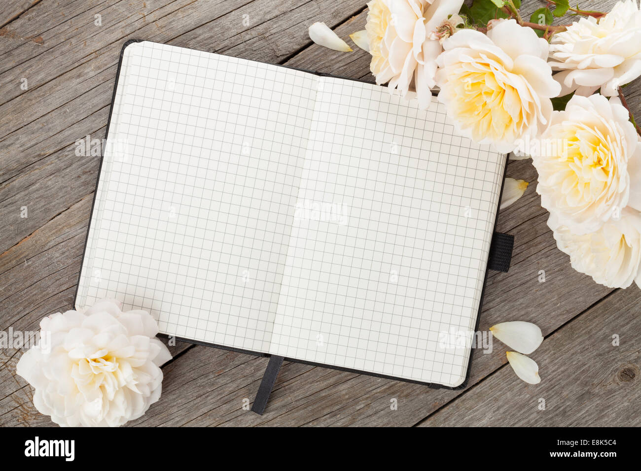 Blank notepad and white rose flowers on wooden table background Stock ...