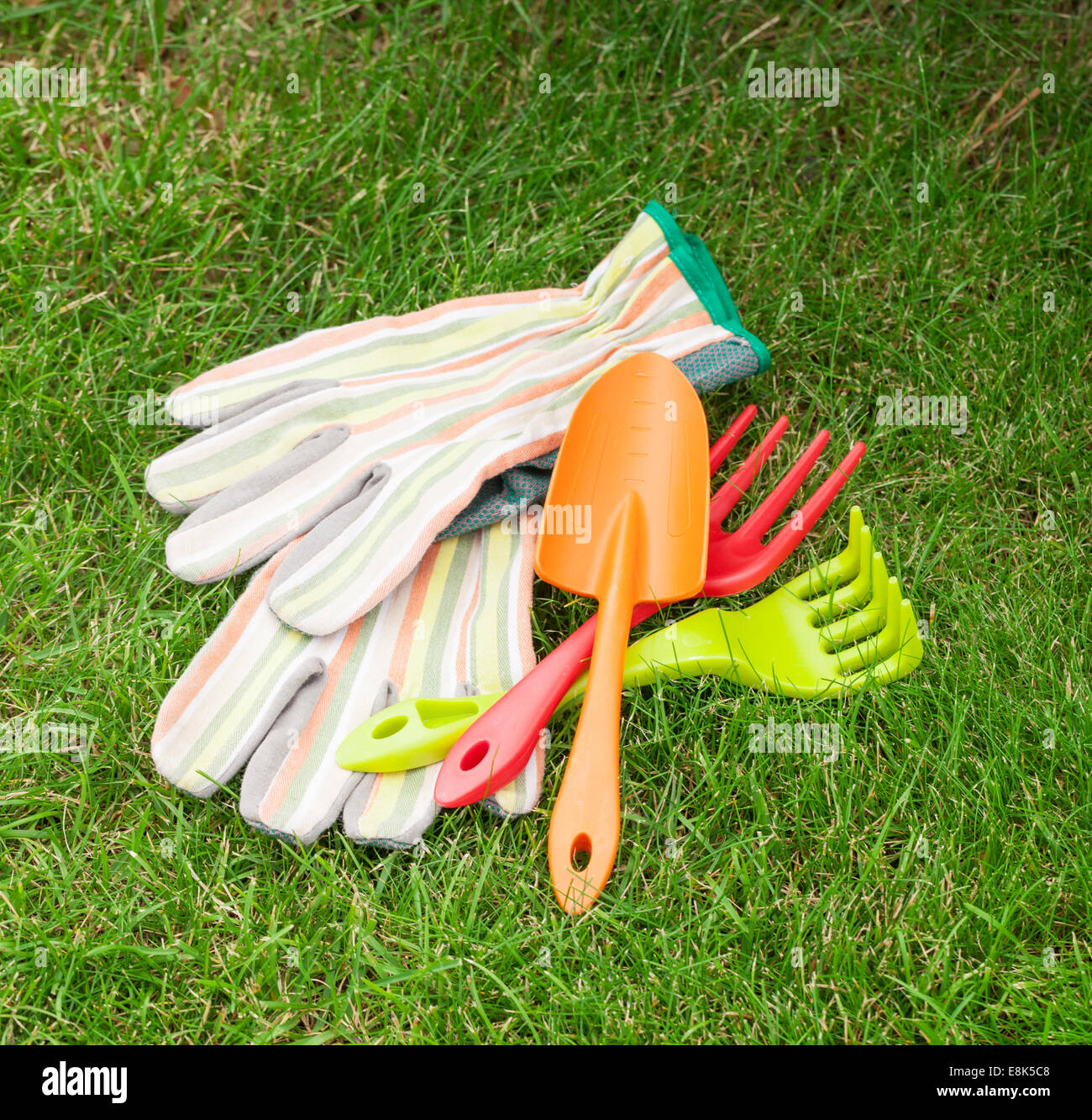 Garden tools over green grass field Stock Photo - Alamy