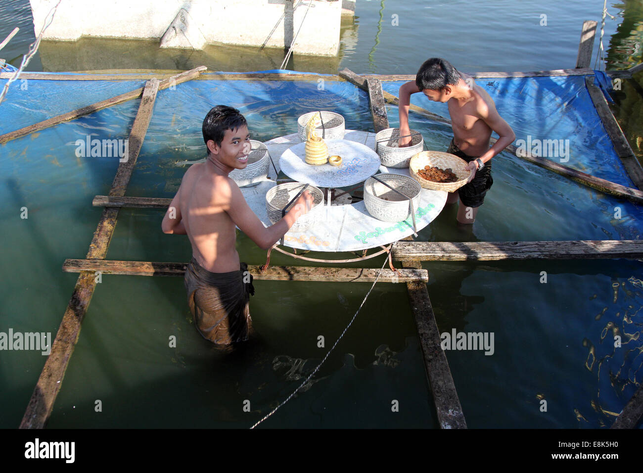 Two boys collect coins thrown into the water at Antaka Yele Pagoda on ...