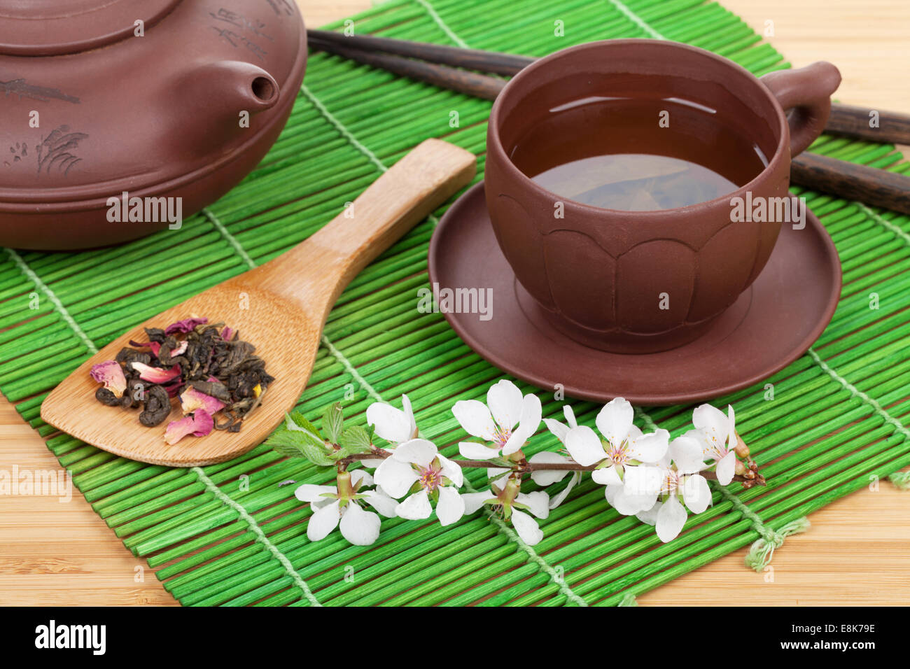 Japanese green tea and sakura branch over mat and bamboo table Stock ...
