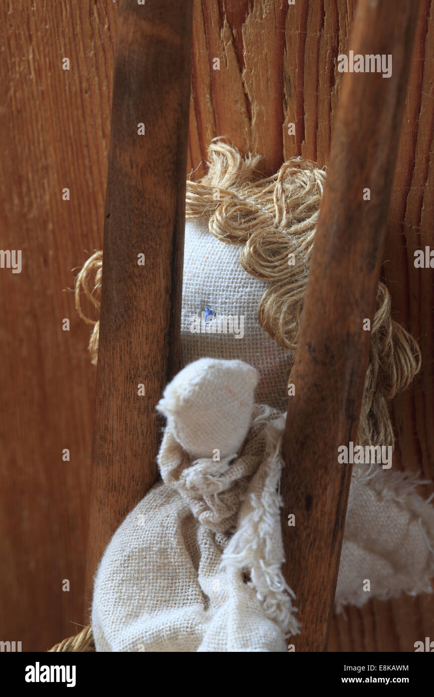A rag doll is stuck in the backrest of a wooden chair Stock Photo - Alamy