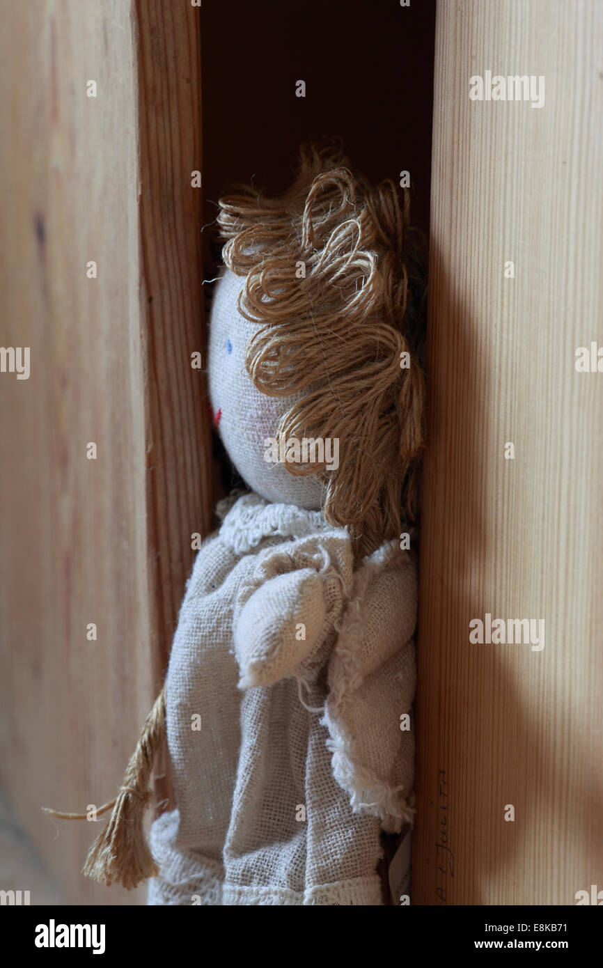 A rag doll is stuck in a wooden cabinet Stock Photo - Alamy
