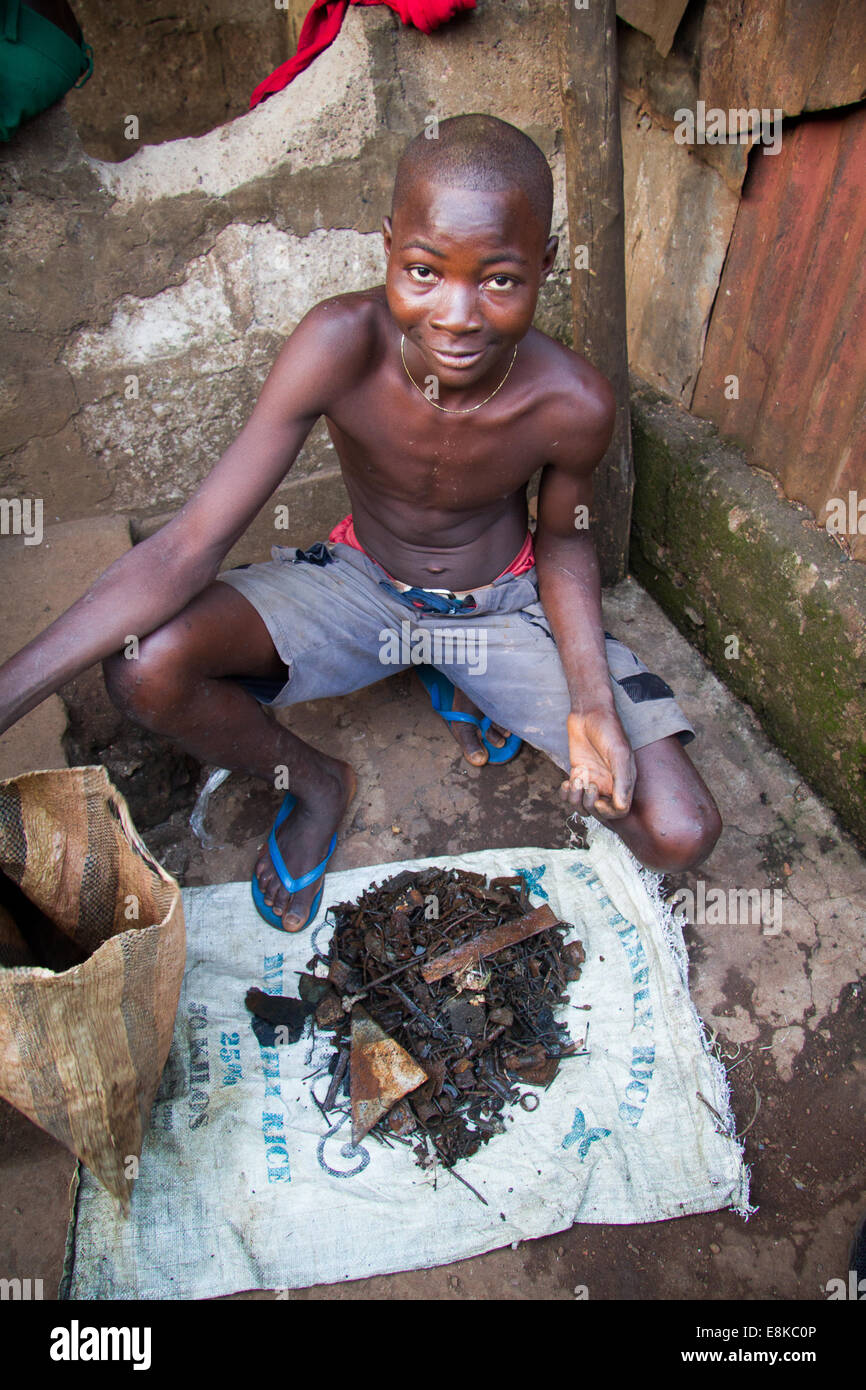 Young man with pile of scrap metal collected collected from polluted ...