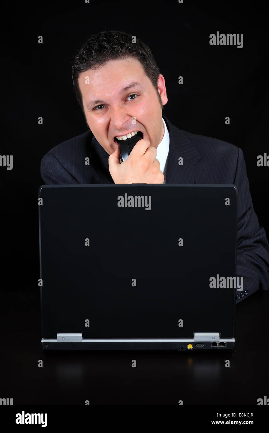 Angry businessman is biting the mouse on the balck background Stock ...