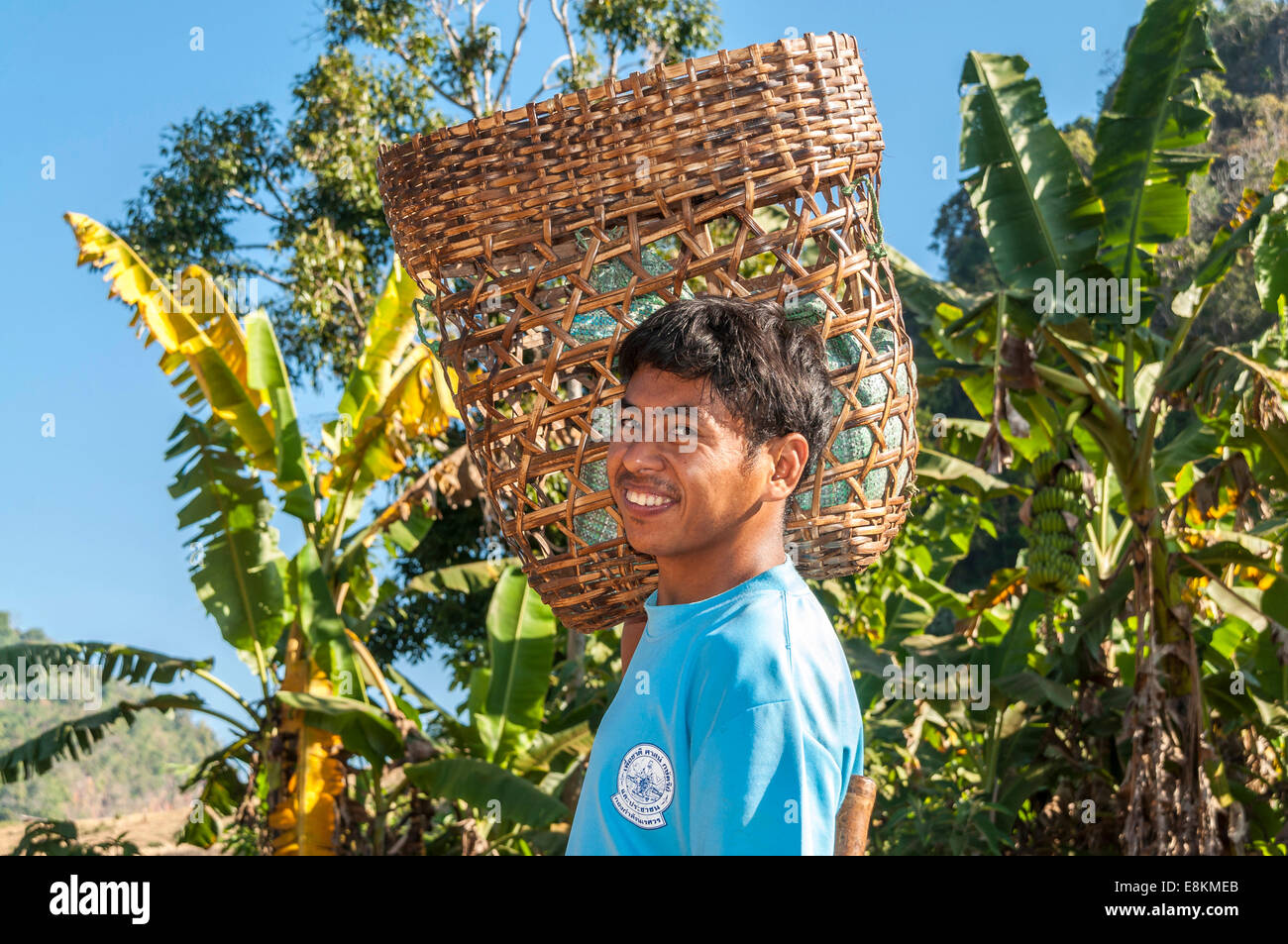 Smiling man from the Lahu people, hill tribe, ethnic minority, carrying ...