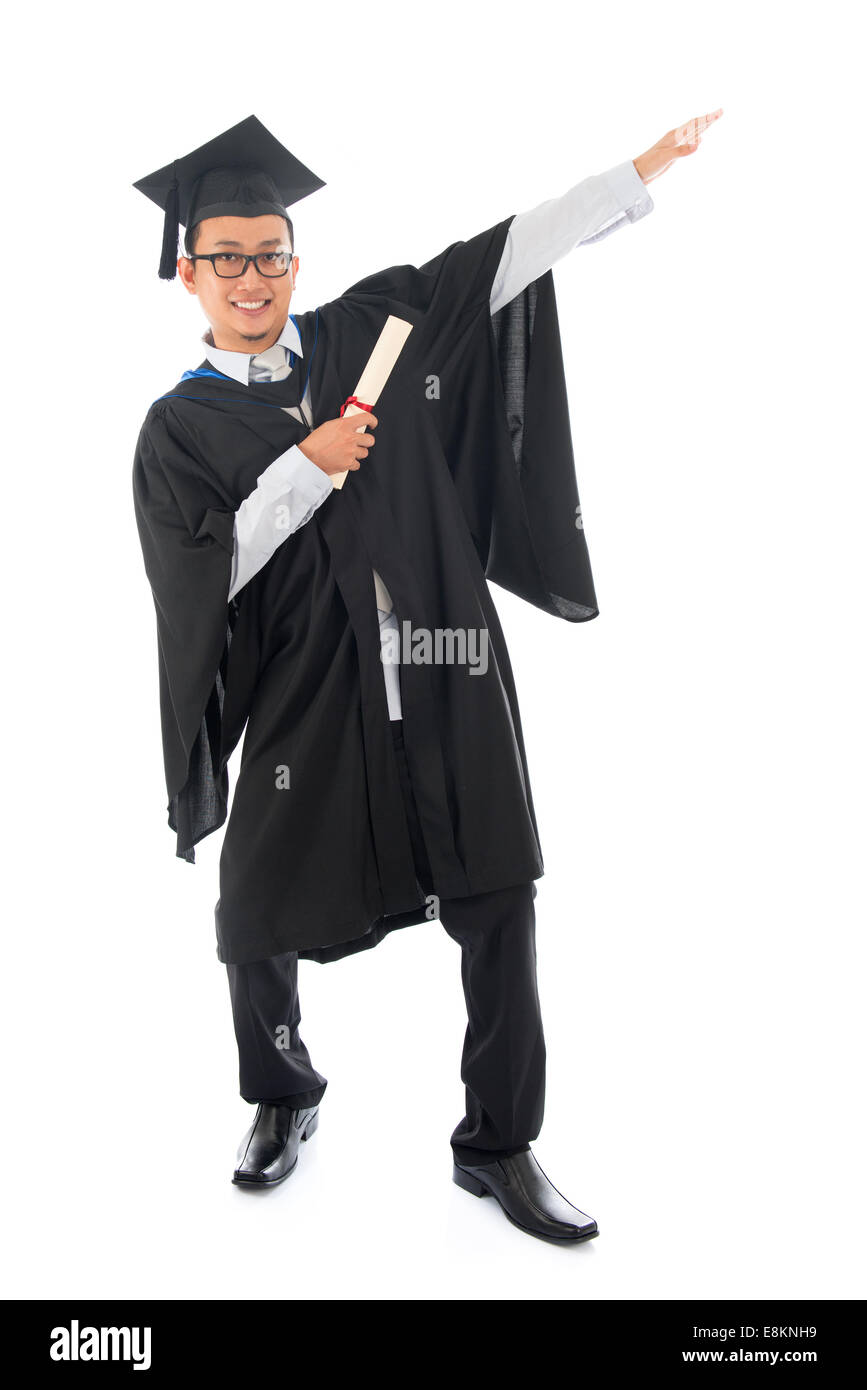 Full length pan Asian university student in graduation gown, standing ...