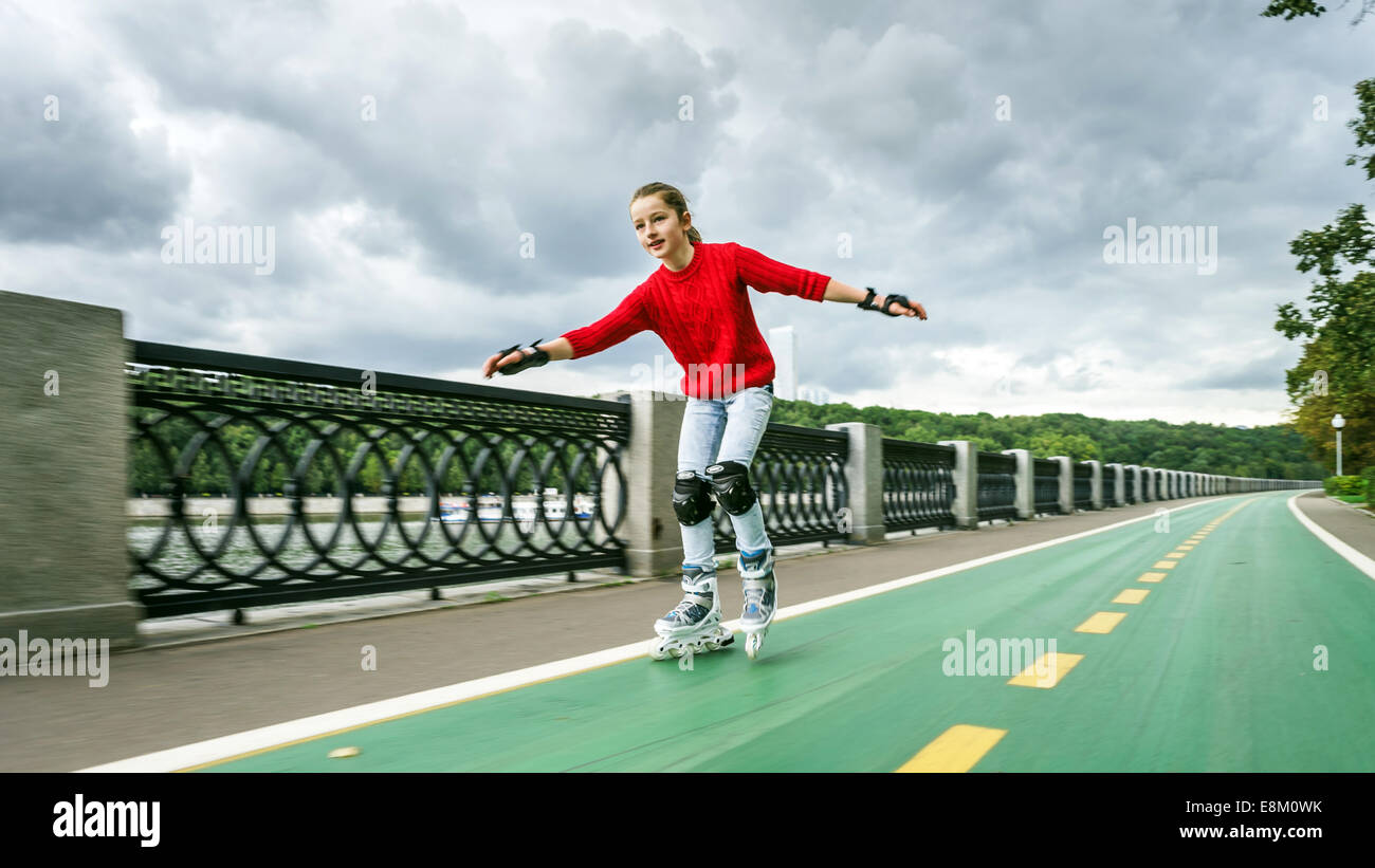 Beautiful teenage girl roller-skating fast in public park Stock Photo ...