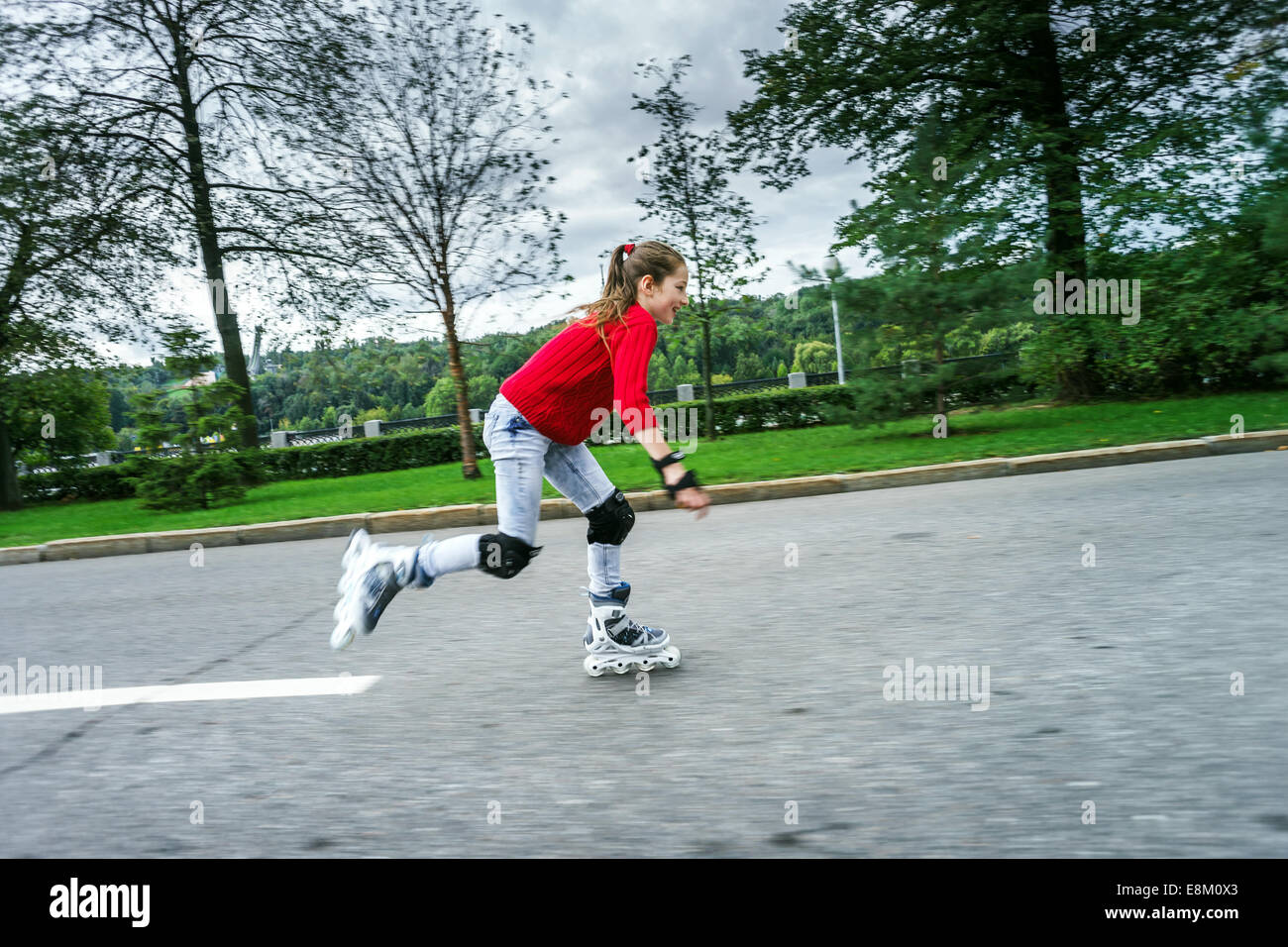 Beautiful teenage girl roller-skating fast in public park Stock Photo ...
