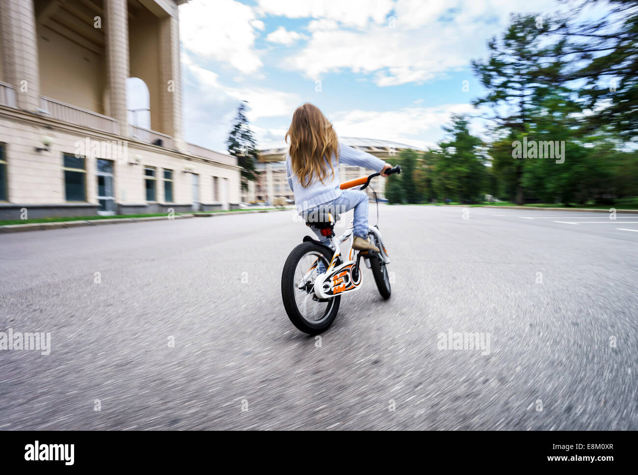 Cute little girl riding fast by bicycle in public park Stock Photo - Alamy
