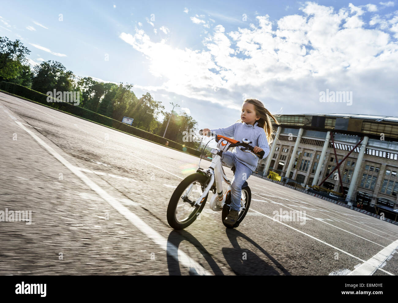 Cute little girl riding fast by bicycle in public park Stock Photo - Alamy