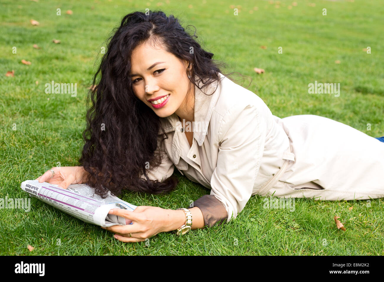 young woman reading the paper in the park Stock Photo - Alamy