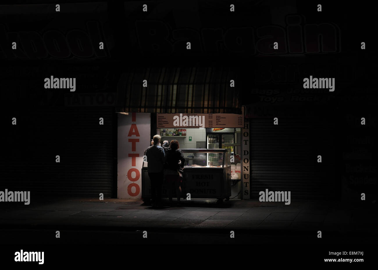 Night view man and woman standing counter fast-food stall selling ...