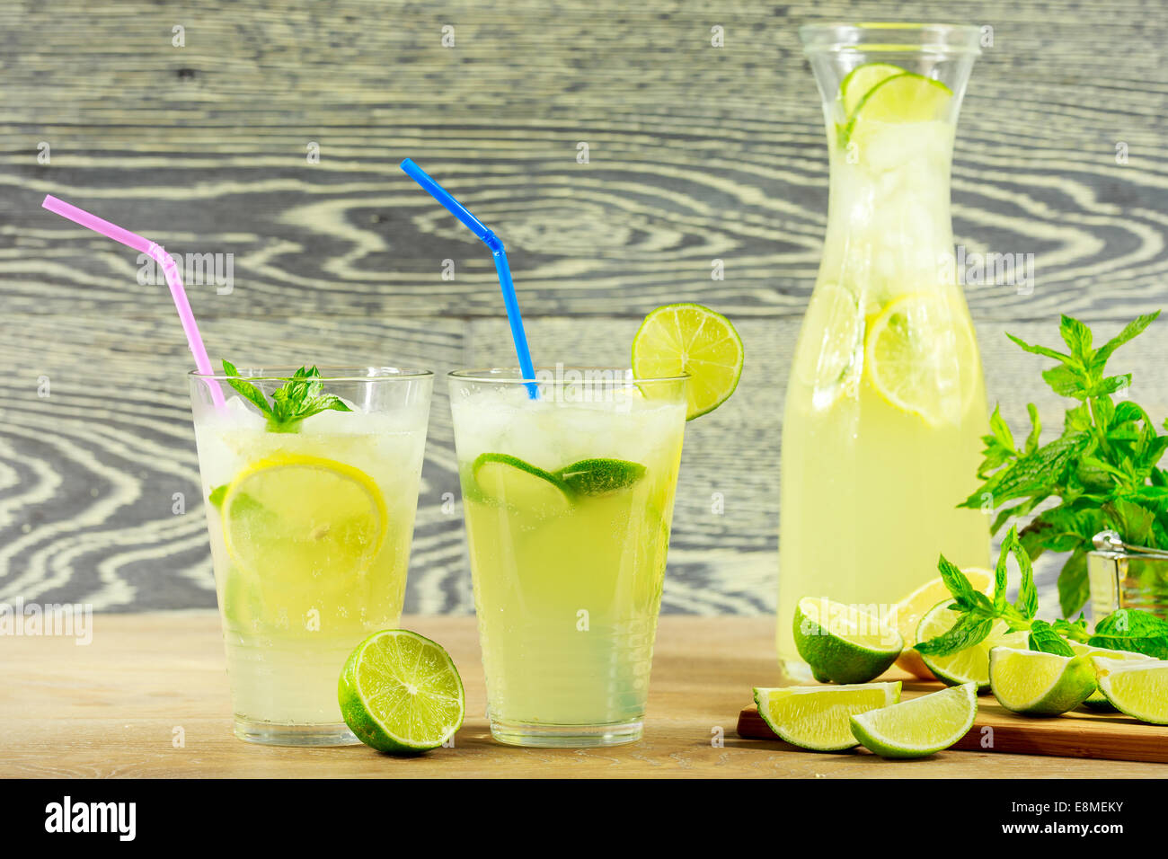 Refreshing lemonade drink and ripe fruits against wooden background ...