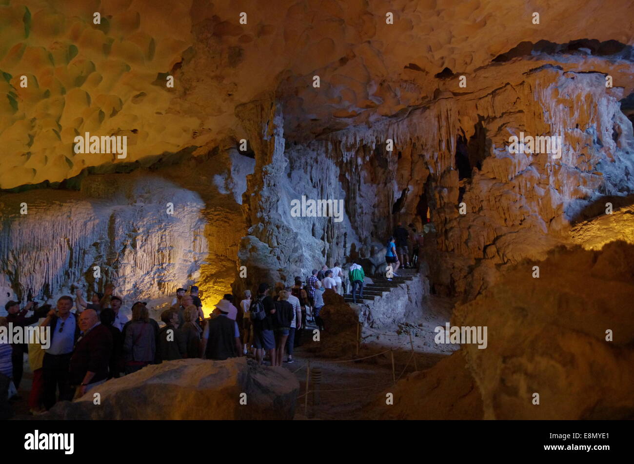 People walking through a cave in Halong Bay Stock Photo - Alamy