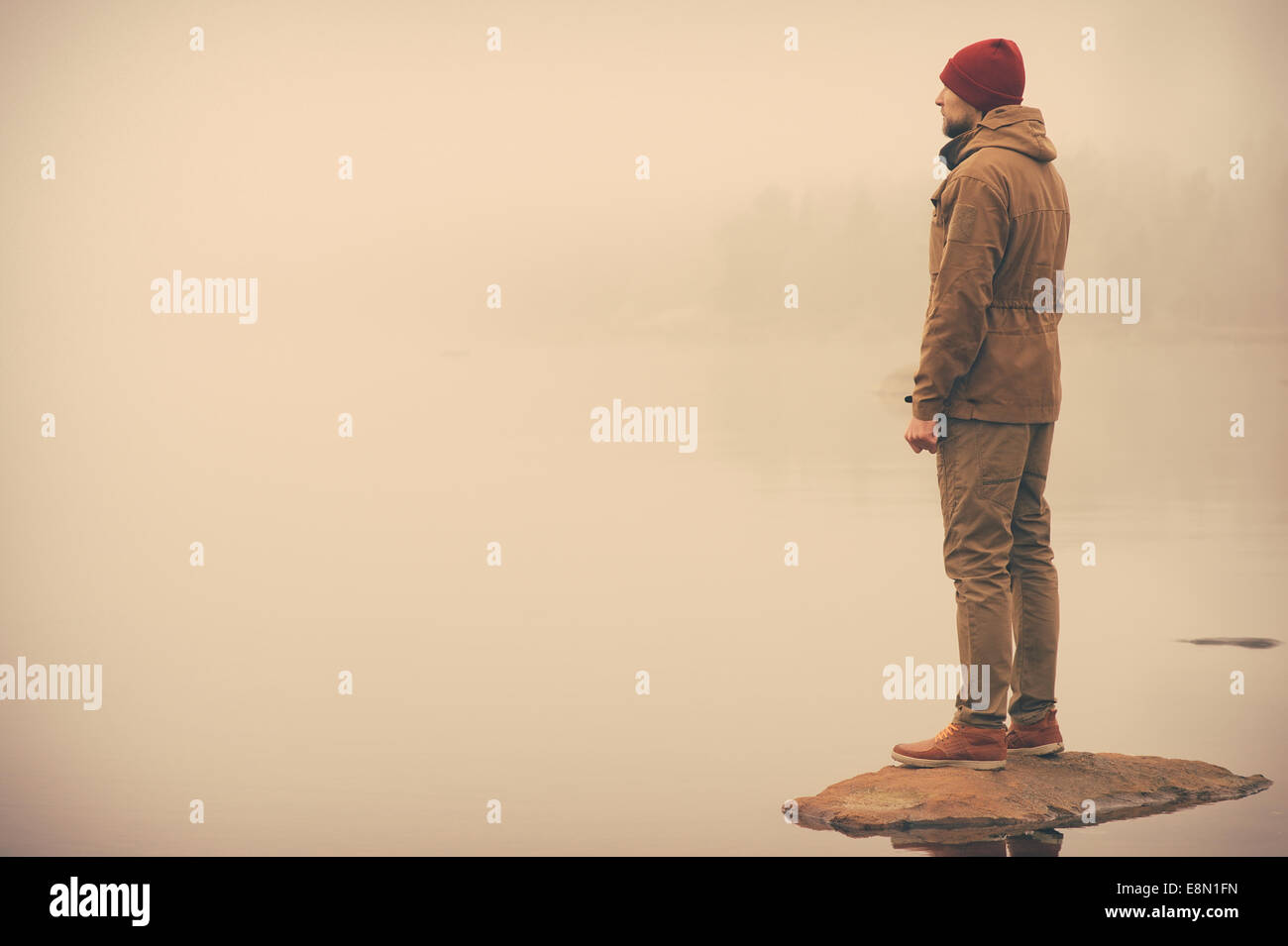 Young Man standing alone outdoor with foggy scandinavian nature on ...