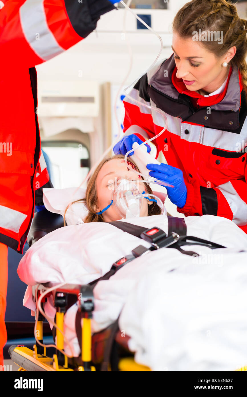 Emergency doctor and nurse or ambulance team transporting accident ...