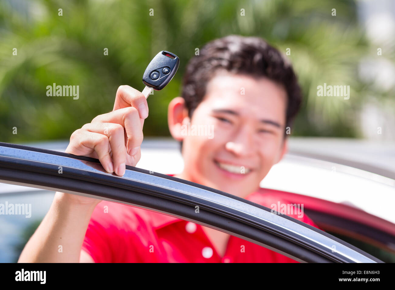 Asian man showing key of his new car Stock Photo - Alamy