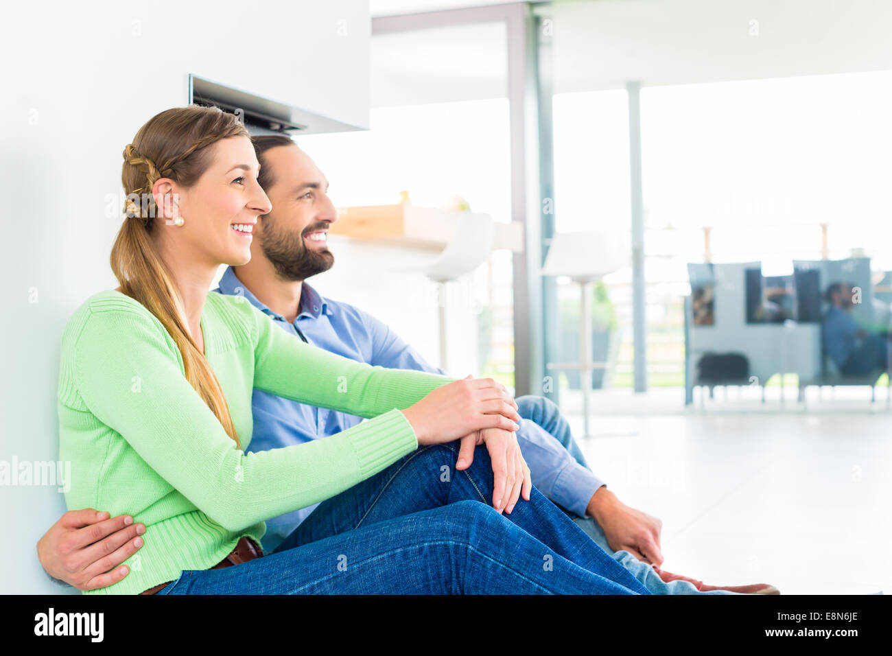 Couple sitting together on living room floor enjoying view Stock Photo ...