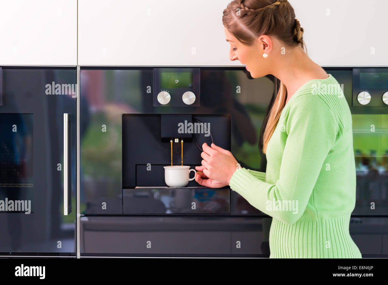Woman using fully automatic coffee machine at home Stock Photo - Alamy