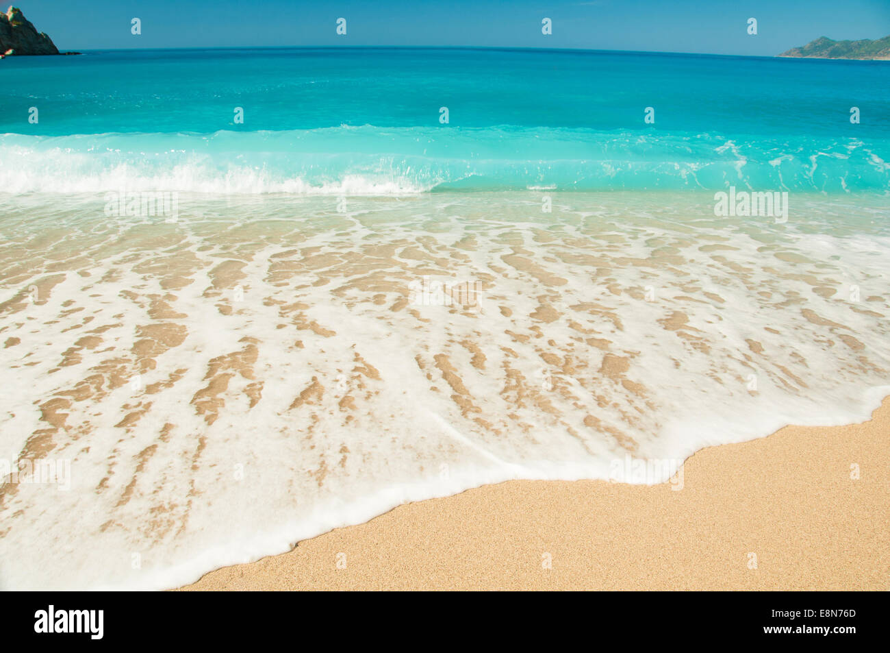 Beautiful surf on the beach. Mountains on the horizon Stock Photo - Alamy