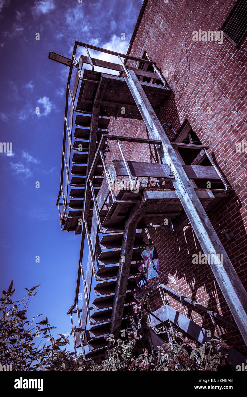 A Dutch angle shot of a red brick and concrete office building, with a ...