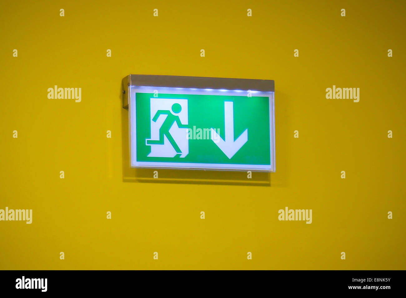 Emergency exit sign with a yellow background Stock Photo - Alamy