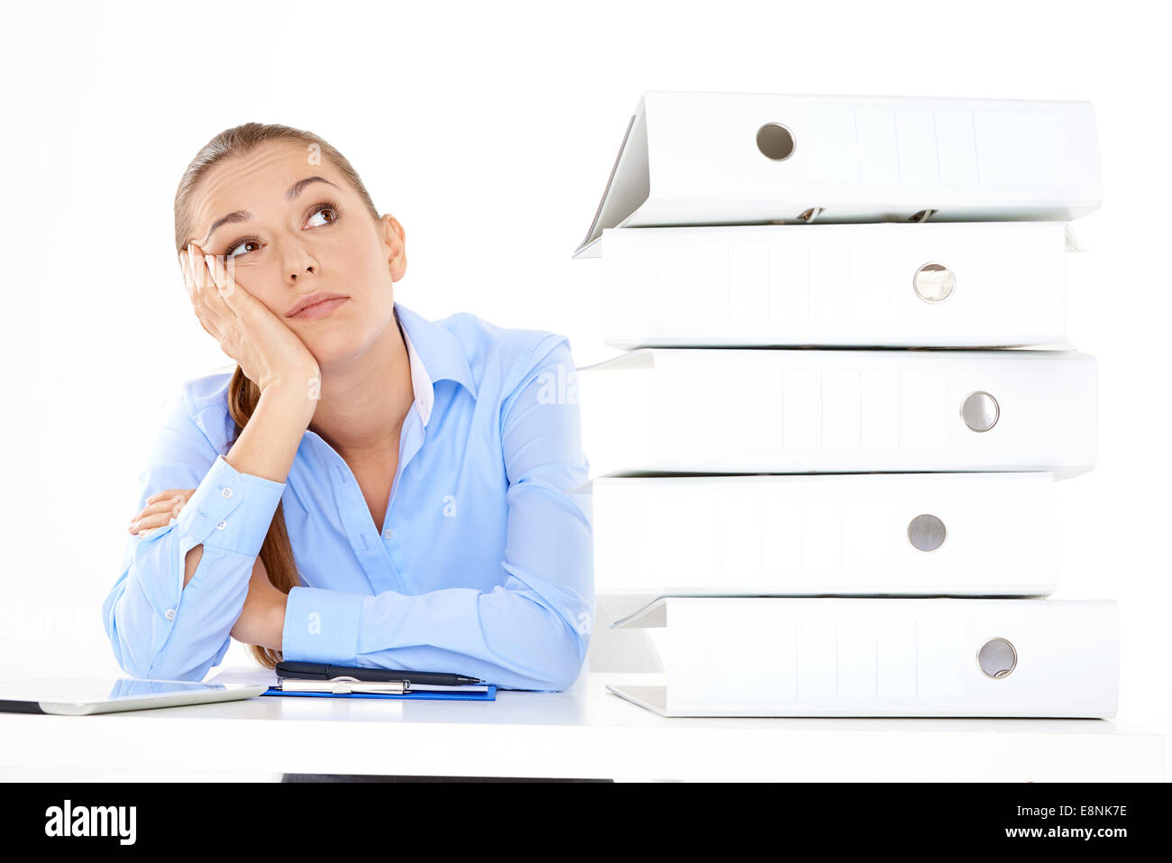 Bored female employee with a lot of work left to do on white background ...