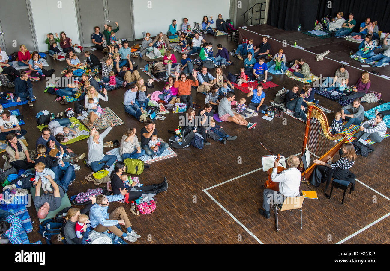 Many parents with their children and babies listen to a 'baby concert ...