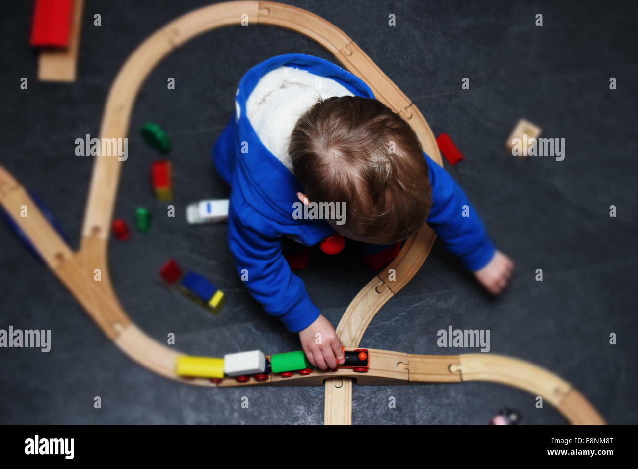 A boy playing with a toy train set Stock Photo - Alamy