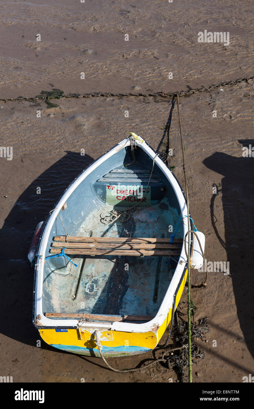 Small tender (boat) attached to its mooring by a rope line and resting ...