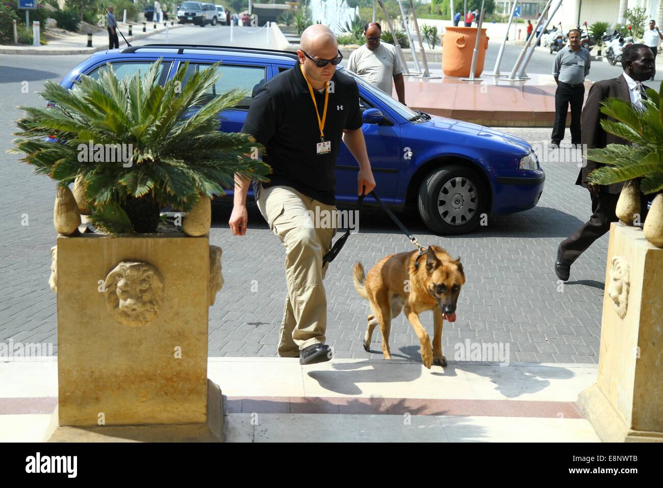 Cairo, Egypt. 12th Oct, 2014. A security officer walks with his dog as ...
