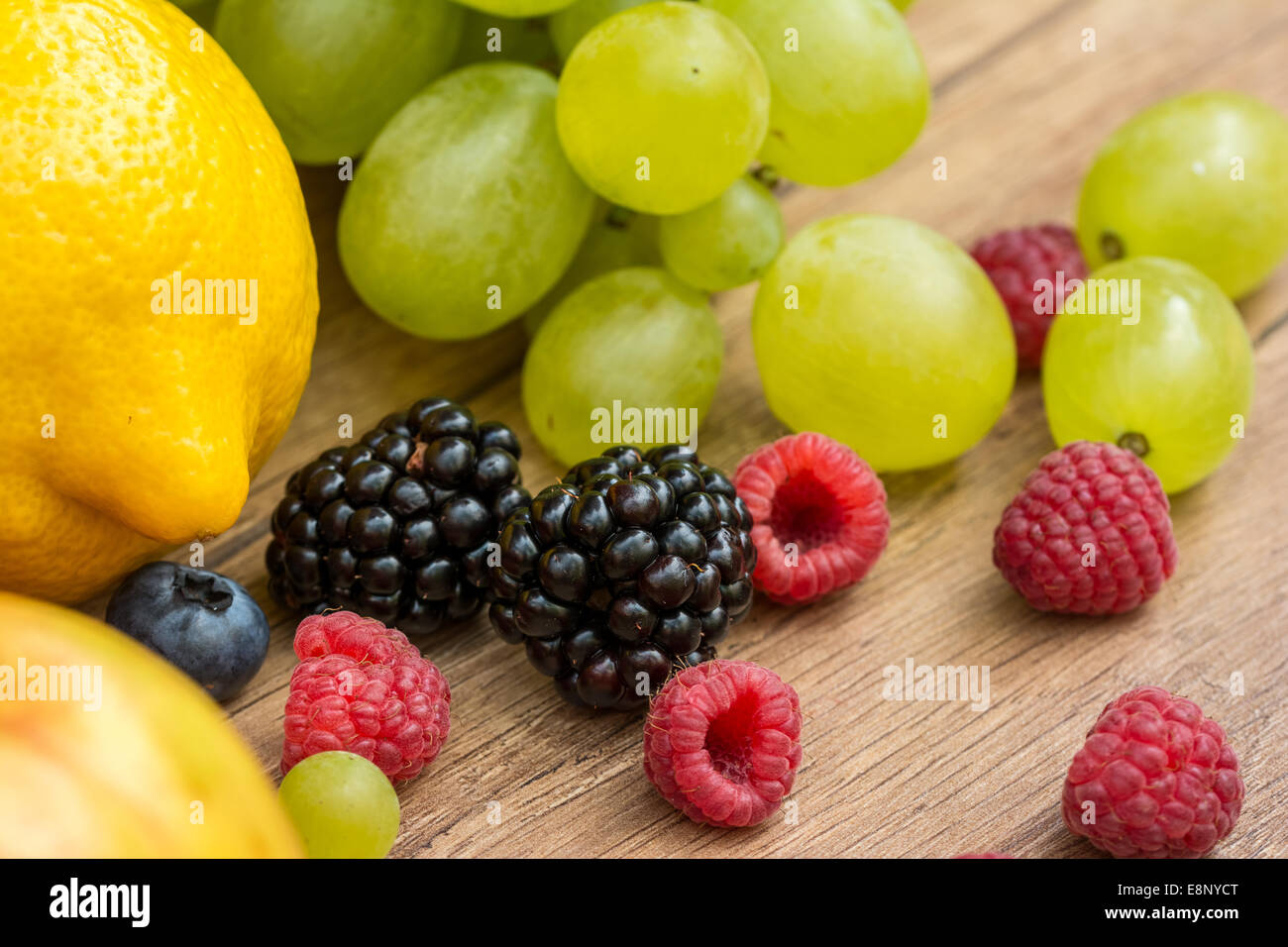 Lemon, Grapes And Berries Summer Fruits On Wood Table Stock Photo - Alamy