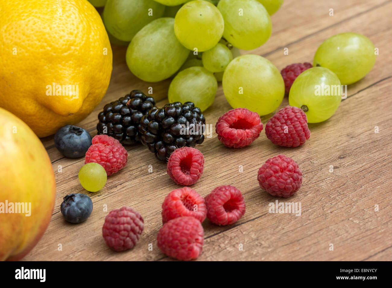 Lemon, Grapes And Berries Summer Fruits On Wood Table Stock Photo - Alamy