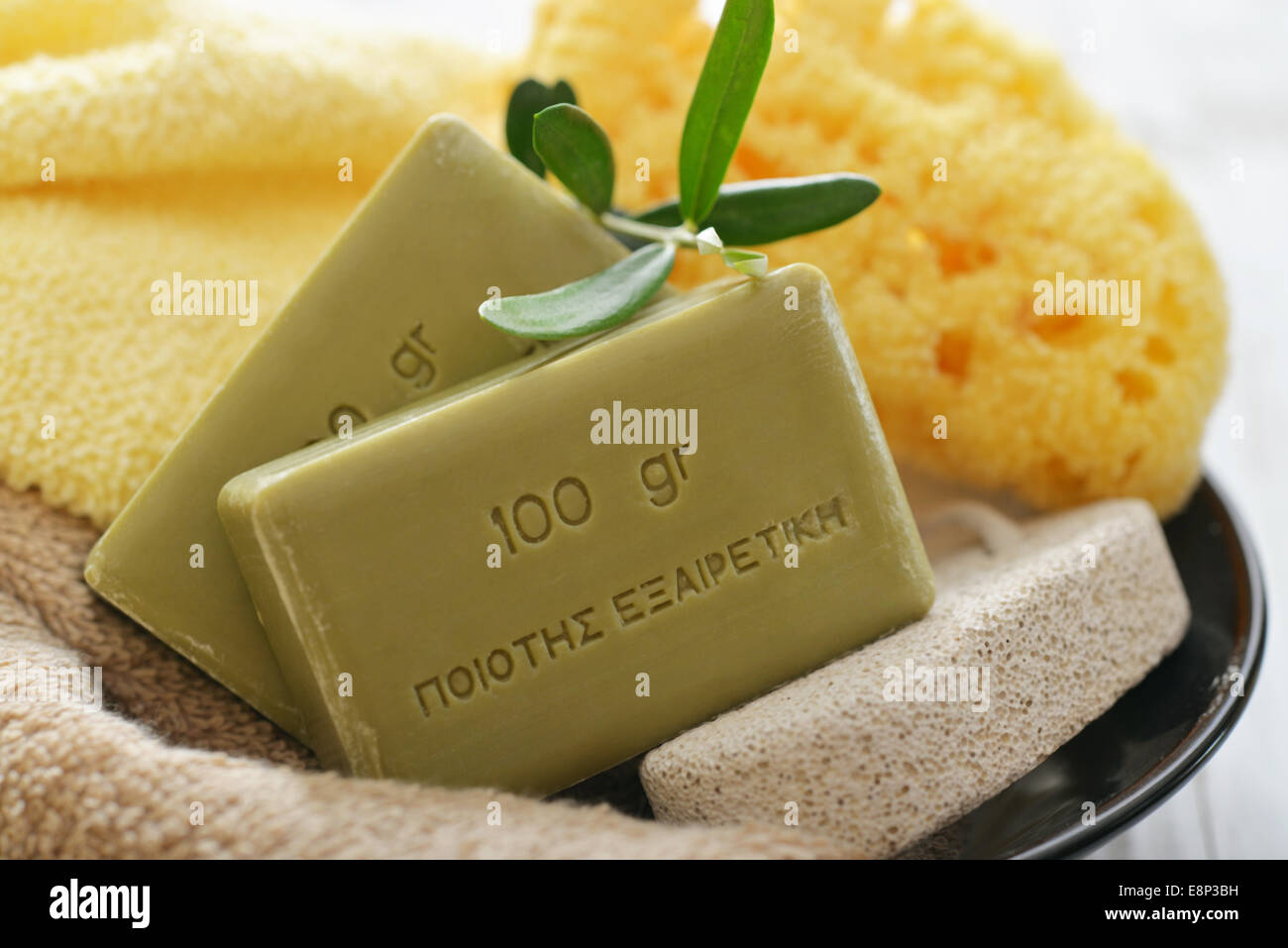 Greek olive soap with bath towels and bath sponge in bowl closeup Stock ...