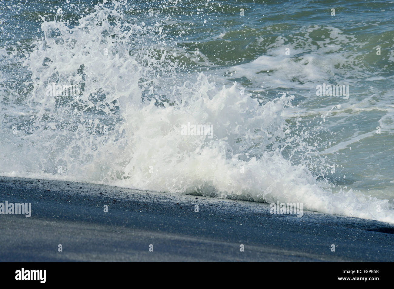 Water splashing at a concrete wall by the western edge of the island ...
