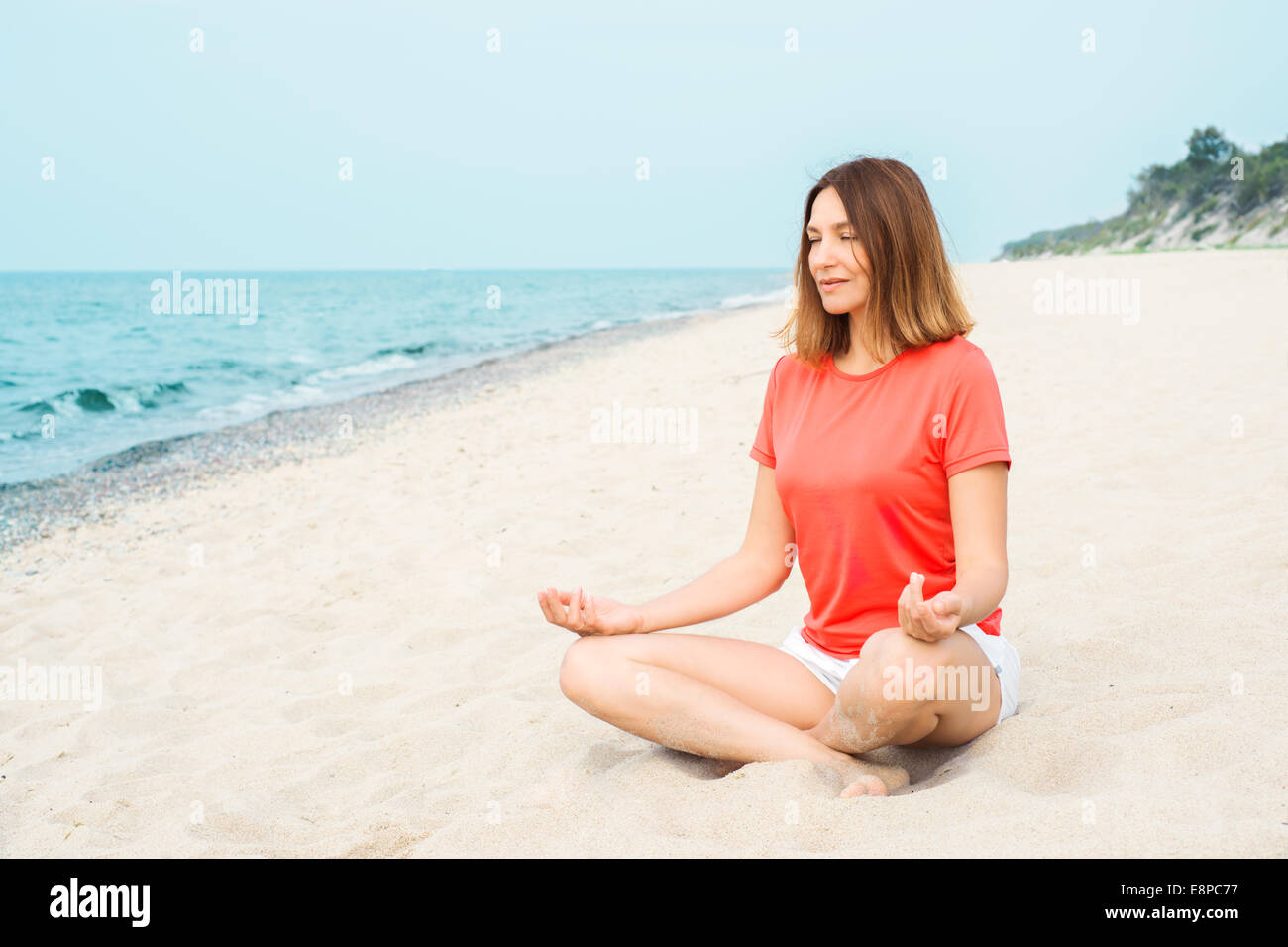 Woman meditating by the sea Stock Photo - Alamy
