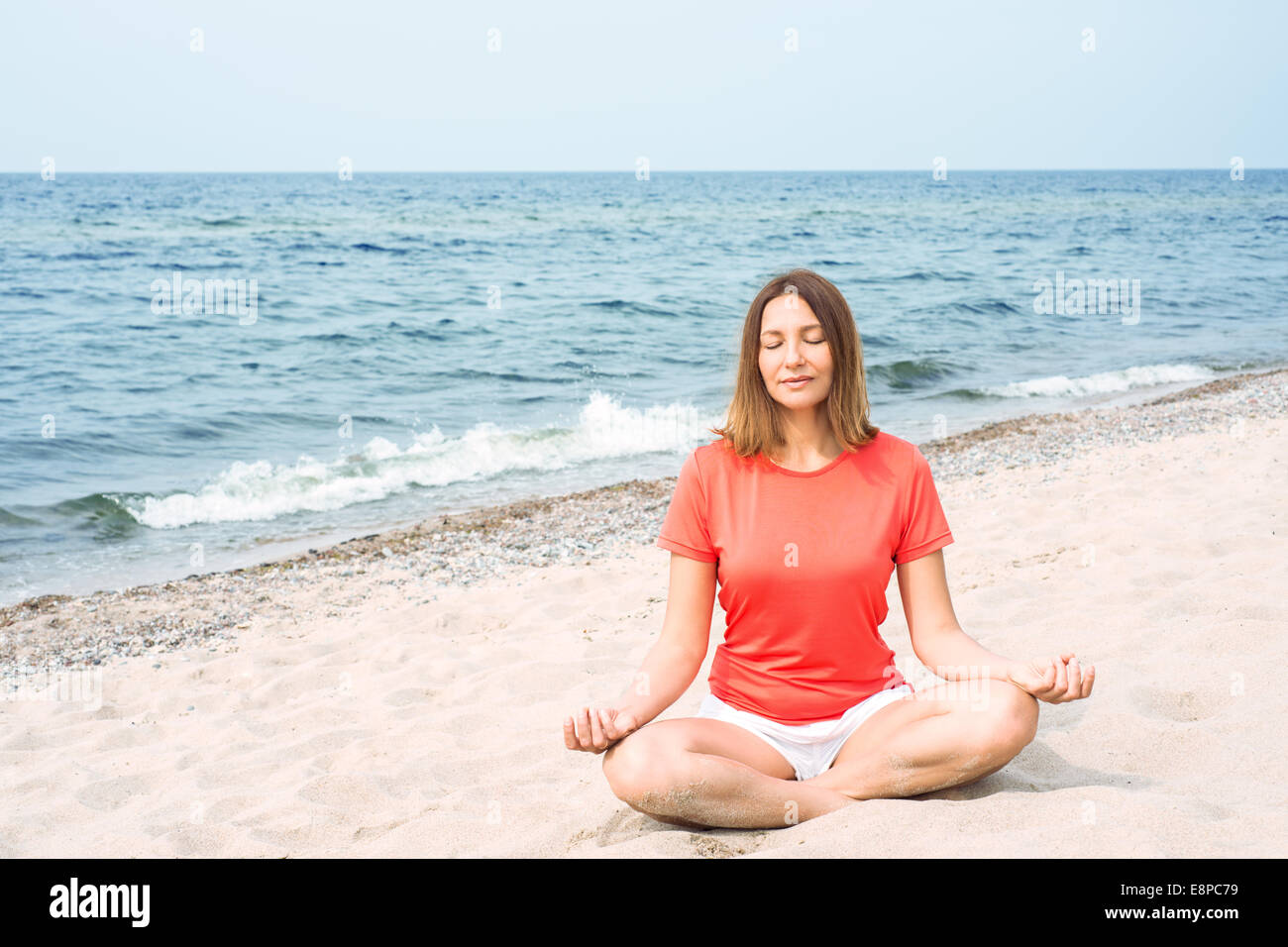 Woman meditating by the sea Stock Photo - Alamy