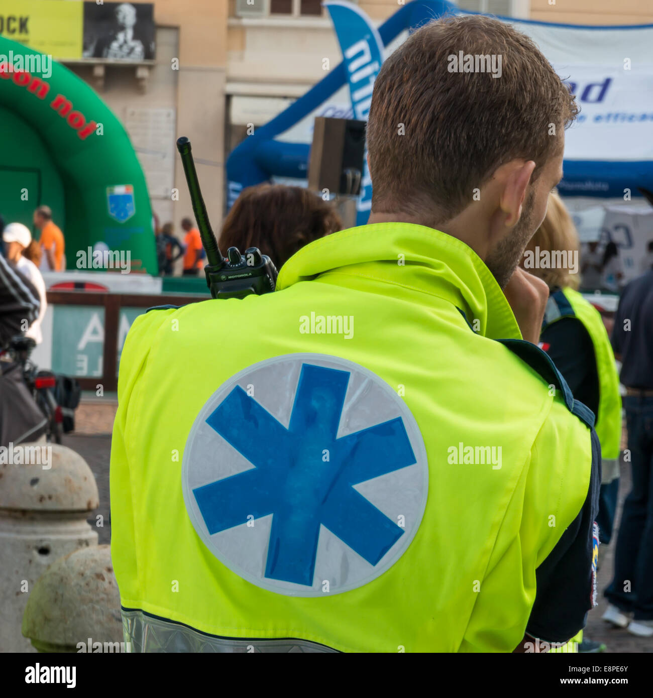 Paramedic with radio equipment wait for call; blue and yellow dressed ...